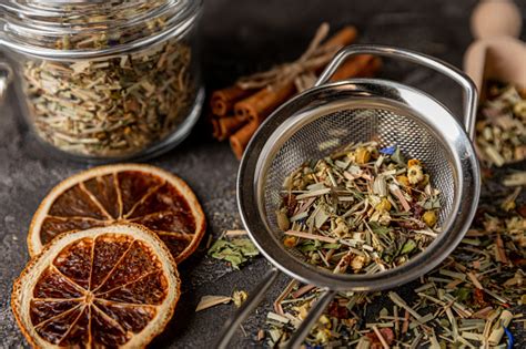 어두운 대리석 배경에 계피와 감귤류 조각이 있는 여과기에 녹차 잎이 있는 허브 차 차 개념입니다 위에서 본 모습 공간을 복사합니다 0명에 대한 스톡 사진 및 기타 이미지