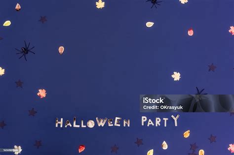 가을 잎이있는 짙은 자주색 파란색 배경에 황금 글자로 만든 할로윈 파티 문구 레터링 검은 별 스팽글 및 텍스트를위한 복사 공간이있는 거미 선택적 초점 색종이 조각에 대한