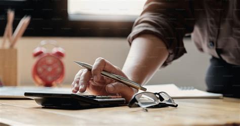 사무실 및 비즈니스 작업 배경 세금 회계 통계 및 분석 연구 개념에서 나무 책상에 수학 금융을 수행하기 위해 계산기를 사용하는 비즈니스 여성 사진 Unsplash의