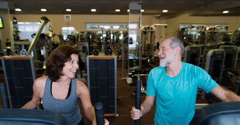체육관에서 유산소 운동을 하고 타원형 트레이너 기계에서 운동하는 스포츠 의류를 입은 아름다운 노인 커플 스포츠 피트니스와 건강한 라이프스타일 개념 사진