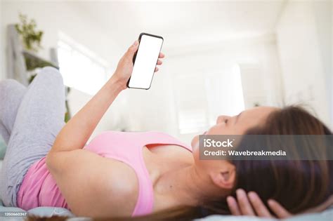 아시아 여자 침대에 누워 화면에 복사 공간을 가진 스마트 폰을 사용 하 여 Brand Name Smart Phone에 대한 스톡 사진 및 기타 이미지 Brand Name