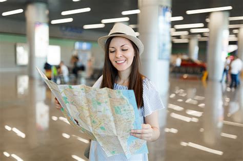 젊은 꽤 여행자 관광 여자 모자 종이 지도 들고 로비 홀 국제 공항에서 기다리는 동안 경로 검색 합니다 주말도 주에 해외 여행 하는 승객 공기 비행 개념입니다 건축에 대한