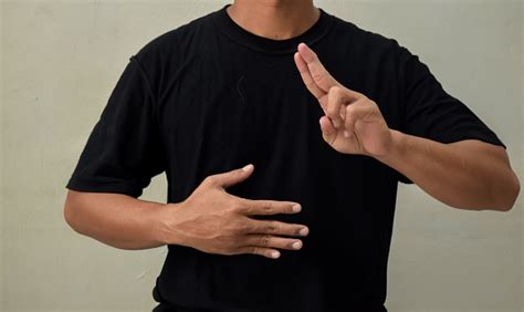 젊은 남자가 그의 배에 손바닥을 대고 다른 사람을 들어 올리면서 수화로 단어 교사를 보여줍니다 매우 기쁜에 대한 스톡 사진 및 기타 이미지 Istock