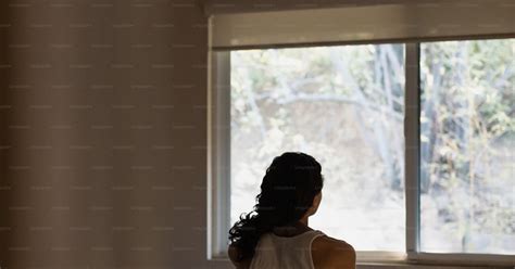침대에 앉아 창밖을 내다보는 여자 사진 Unsplash의 정신 건강 이미지
