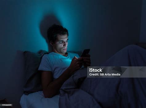 스마트 폰 중독자 남자는 소셜 미디어에 데이트 채팅 유혹 휴대 전화 확인 좋아하고 추종자를 사용하여 침대에서 늦은 밤에 깨어 인터넷 중독 및 모바일 남용 Brand Name