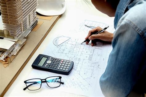 Premium Photo Midsection Of Female Engineer Drawing Blueprint In Office