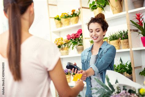 Payment Process Positive Nice Woman Standing Opposite Her Customer While Making A Payment Stock