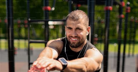 운동 중 스포츠 바에서 왼발을 향해 스트레칭하면서 이어폰으로 음악을 듣는 행복한 젊은 스포츠맨 사진 Unsplash의 스트레칭 이미지