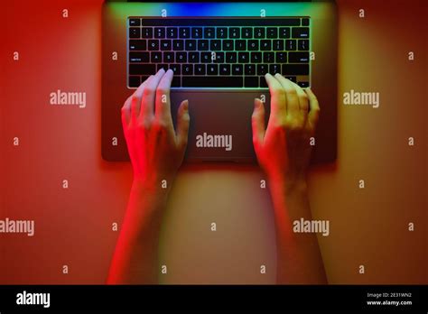 Hands On A Modern Laptop Keyboard Top View And Bright Lit Red