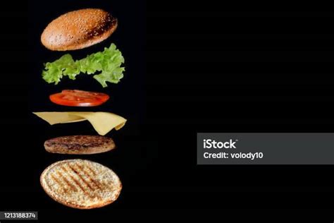 어두운 배경에 고립 된 작은 나무 도마에 재료 햄버거 또는 치즈 버거를 비행 테이블 위의 공중에 떠있는 햄버거 텍스트를 위한