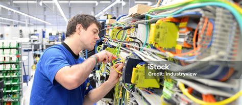 젊은 운영자는 현대 하이테크 공장에서 기계를 조립 산업 공장스위치 캐비닛의 생산 건설 기계류에 대한 스톡 사진 및 기타 이미지 건설 기계류 건설 산업 공장 산업 건물