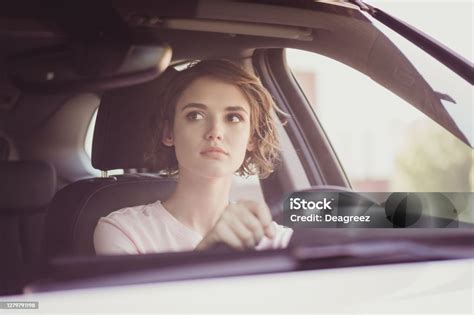 매력적인 예쁜 여성 진정 농축 얼굴 손 잡고 스티어링 휠 드라이브 자동차 조심스럽게 다른 드라이버가 실내에서 흰색 셔츠를 입고 회전을 기다립니다 T 셔츠에 대한 스톡 사진
