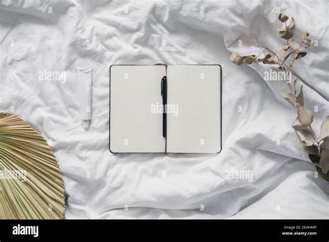 Open Notepad With Blank Pages In Textile White Background Surrounded By Dried Flowers Home