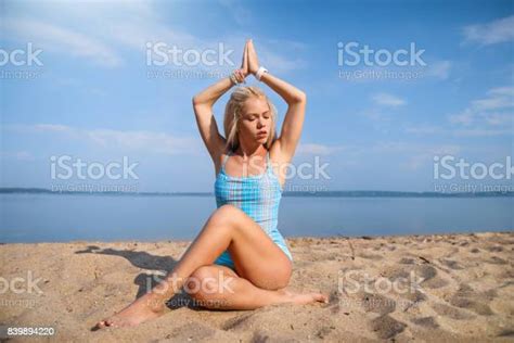 파란 옷 입은 금발 긴 머리 여자 스트레칭와 떠오르는 해의 아름 다운 해변에 요가 하 고 건강한 생활방식에 대한 스톡 사진 및 기타 이미지 건강한 생활방식 균형 금발