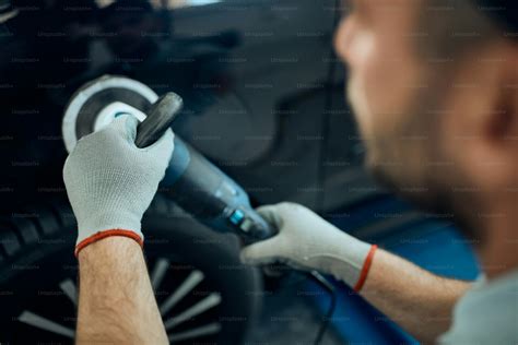 자동차 서비스 작업장에서 자동차를 연마하는 작업자의 클로즈업 사진 Unsplash의 노동 이미지