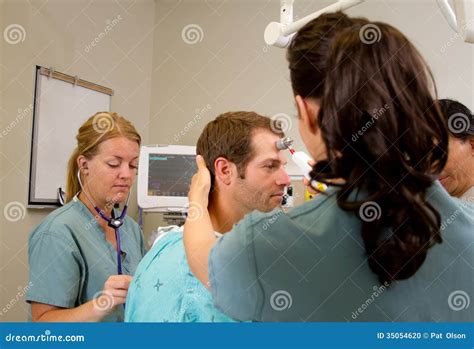 Nurse Assessing Stroke Victim By Raising Arms Stock Image