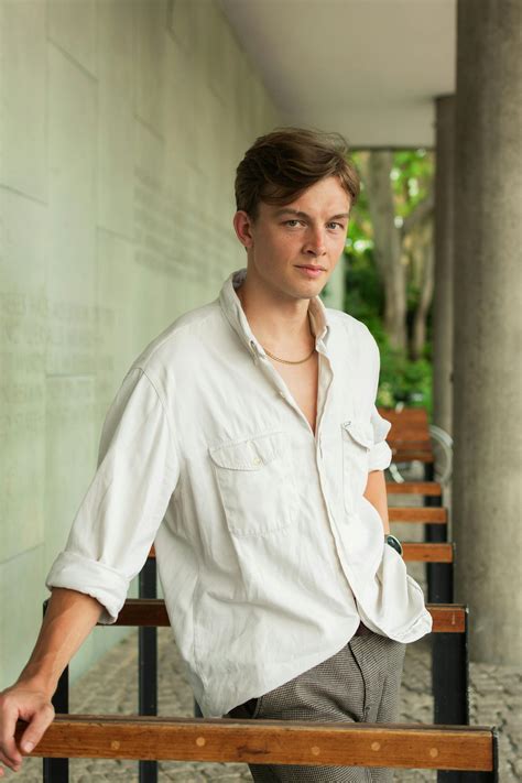 개인 스타일 건축 고요한 남성 모델 남성 패션 낮 녹지 도시 경관 도시 패션 도시의 미니멀리스트 벽돌 벽 보도 부드러운 조명 세련된 복장 수직