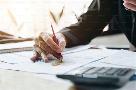 사업가 또는 회계사가 재무 데이터 보고서 회계 문서 및 사무실에서 노트북 컴퓨터를 계산하기 위해 계산기로 작업하는 연필을 들고 있는 클로즈업 비즈니스 개념 사진