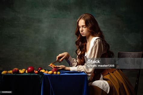 르네상스 시대의 소녀처럼 긴 곱슬 머리를 가진 매력적인 빨간 머리 소녀의 초상화 어두운 배경에 고립 된 여성 농민 시대 비교 아름다움 예술 동화에 대한 스톡 사진 및 기타