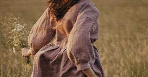 해질녘 여름 초원에서 야생화를 손에 들고 달리는 린넨 드레스를 입은 아름다운 여자 대기 평온한 순간 시골에서 자유로운 저녁을