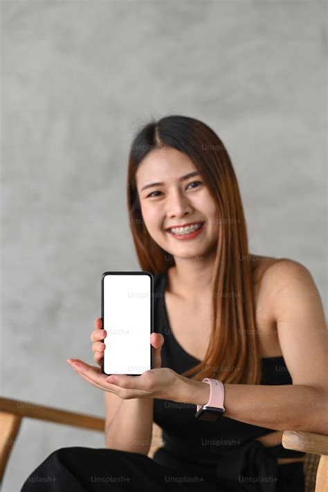 빈 화면으로 스마트폰을 보여주는 젊은 아시아 여성의 초상화 사진 Unsplash의 사진술 이미지