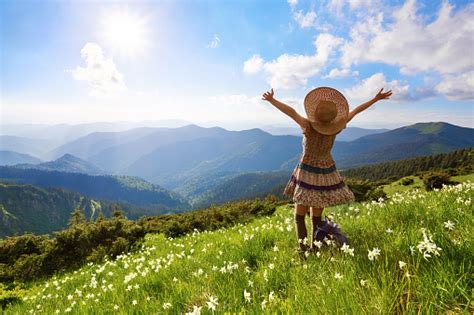 산 풍경에 잔디밭에 Hipster 여자 드레스 스타킹과 밀 짚 모자에 구름으로 하늘을 보고 유지 됩니다 특별 한 여름 풍경입니다