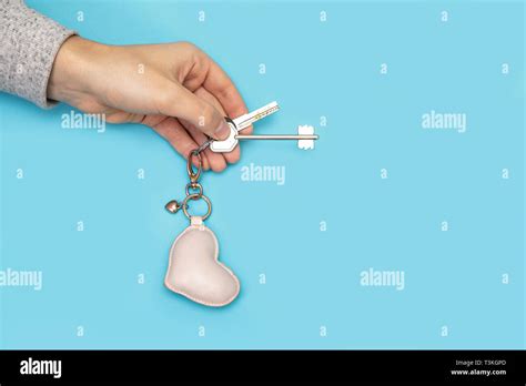Man Arm Out Holding A New Key Men S Hands Give The Keys On A Blue Background Stock Photo Alamy