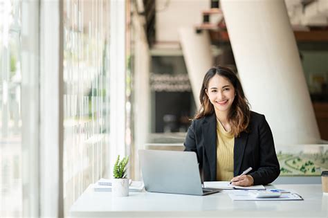 서부핑 금융 그래프를 하고 있는 젊은 아시아 사업가가 노트북을 사용하던 중 친구 인터넷 연결 비즈니스 여성을 사용하여 해외에서 숙제 영상 통화를 하는 동안 컴퓨터를 사용하여