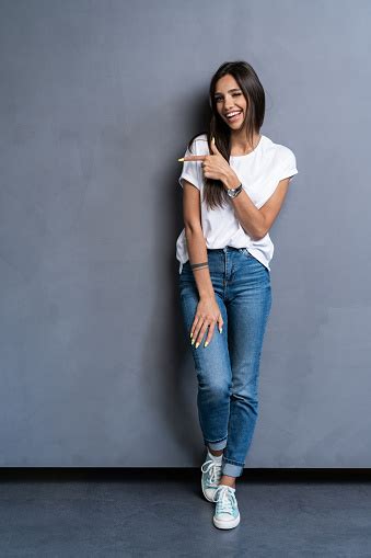 회색 배경에 서 있는 미소 캐주얼 여자의 전체 길이 초상화입니다 카메라를 보고 있습니다 20 29세에 대한 스톡 사진 및 기타 이미지 20 29세 갈색 머리 명랑한