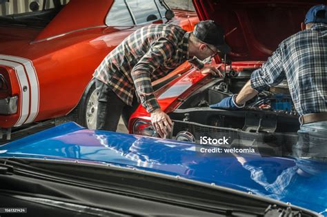 머슬카 후드 아래를 바라보는 두 명의 클래식 자동차 정비사 2명에 대한 스톡 사진 및 기타 이미지 2명 고풍스런 공연 Istock
