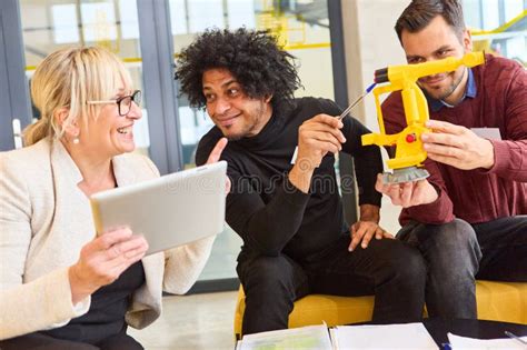 Engineers Examining Robotic Gripper Arm During Industrial Automation Training Session Stock