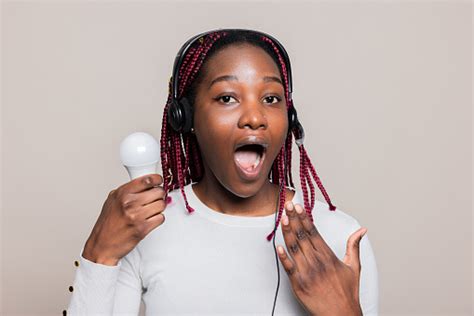 기뻐하고 놀라고 호기심 많고 영리하고 똑똑한 아프리카 계 미국인 여성은 머리띠를 가지고 아이디어가 손에 전구를 들고 창의적인 아이디어의 표시를 가지고 있습니다 고객에 대한