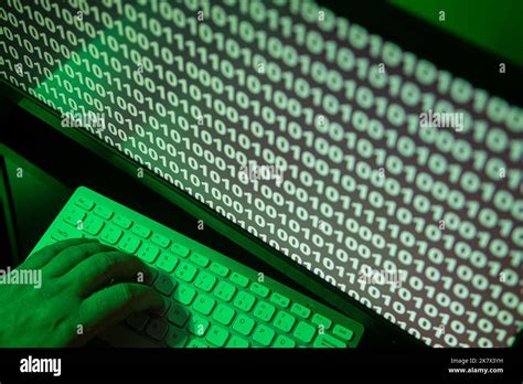 Hand On Keybord With Binary Code On A Screen Green Illuminated Stock