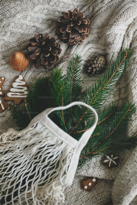 제로 폐기물 크리스마스 휴일 흰색 니트 스웨터에 녹색 가문비 나무 가지 진저 브레드 크리스마스 쿠키 및 솔방울이있는 재사용 가능한 쇼핑백 플라스틱 무료 겨울 장식 사진