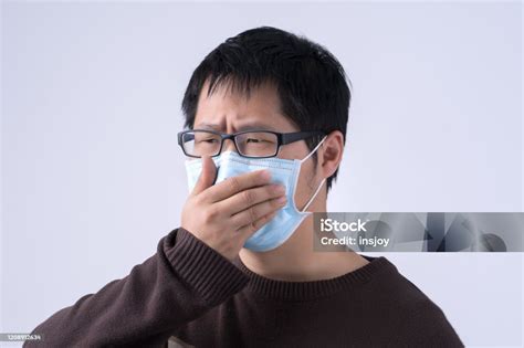 젊은 아시아 남자는 기침 기분이 좋지 흰색 배경에 고립 된 의료 파란색 얼굴 마스크를 착용으로 아픈 구토 30 34세에 대한