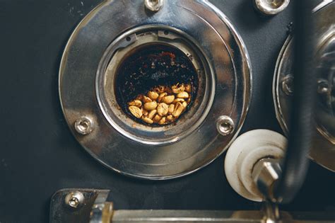 전문 커피 로스터의 클로즈업 사진 분석을 위해 로스팅된 커피 원두의 가시성을 드러내는 작은 둥근 창이 있는 로스트 수준 전문 커피 로스팅 장비 0명에 대한 스톡 사진 및