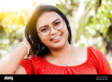 A Portrait Of A Curvy Latin American Woman With Braces Looking At The