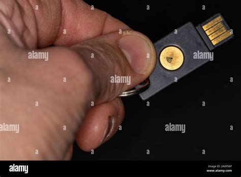 Hand Holding Hardware Security Key For Use With Laptop Or Computer To Ensure Online Data