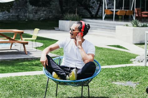 멕시코 시티의 테라스 집에서 음악을 듣고 있는 빨간 헤드폰을 쓴 라틴 남자 사진 Unsplash의 멕시코 이미지