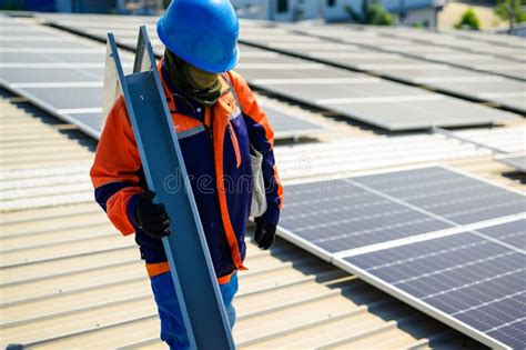 male technician worker installing solar panels on rooftop of industrial