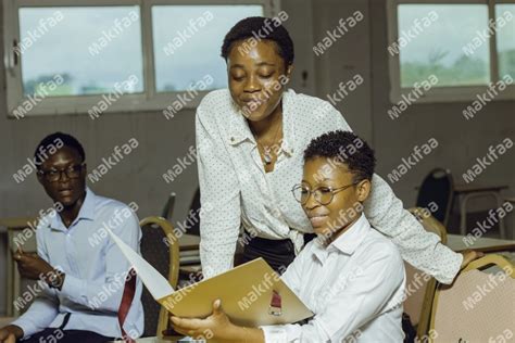 Une Tudiante Souriante Avec Des Lunette Est Assise Montrant Quelque Chose Sa Camarade En