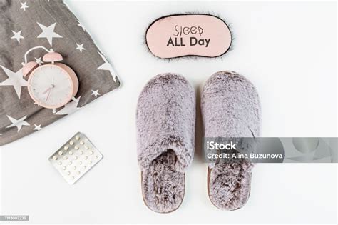 부드러운 푹신한 슬리퍼 회색 색상 베개 눈가리개 알약과 흰색 배경에 고립 된 핑크 알람 시계와 플랫 누워 상단 보기 오버 헤드 모형 템플릿 휴식 시간 잠자기에 대한 스톡