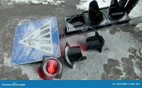 Crushed Crosswalk Sign And Trafic Light Flashing In The Snow Afrer Car