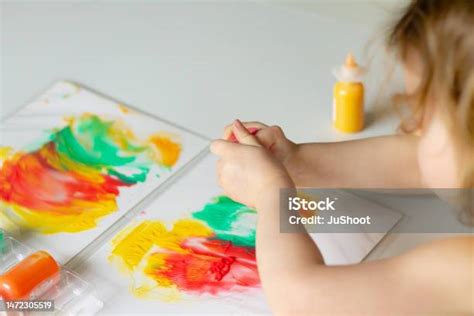 그녀의 손으로 컬러 페인트를 하는 작은 행복한 소녀 학교에서의 자녀 교육을위한 창의적인 활동 공예에 대한 스톡 사진 및 기타
