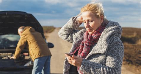 도로에서 노부부는 차에 문제가 있고 여자는 차량 엔진을 보고 있는 동안 도움을 요청한다 사진 Unsplash의 수송 이미지