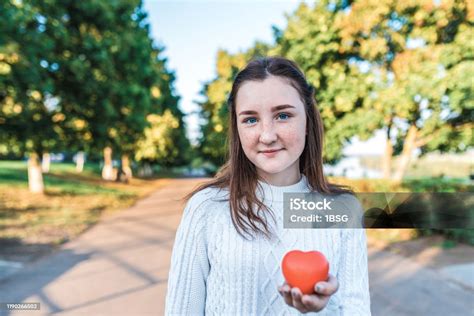 십대 소녀 여름 그녀의 손 빨간 마음 가을 거리에 흰색 따뜻한 스웨터 개념 관리와 사랑 생명을 제공합니다 행복한 미소 텍스트 복사를 위한 여유 공간입니다 어린이와 사람들을