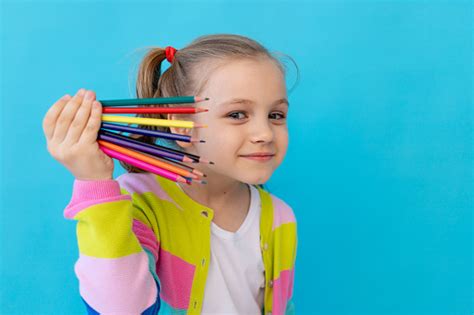 줄무늬 재킷에 색깔의 연필을 가진 귀여운 어린 소녀의 초상화 교육과 드로잉의 개념 사진 스튜디오 파란색 배경 텍스트 장소 6 7 살에 대한 스톡 사진 및 기타 이미지