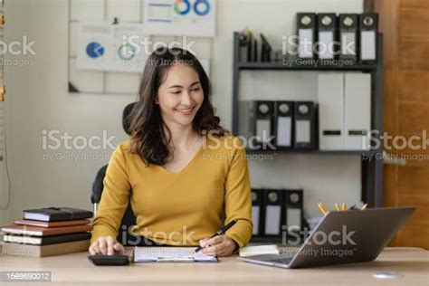 책상에 앉아 노트북으로 문서 작업을 하는 아시아 여성 재무 보고서 사업 계획 투자 금융 비즈니스 분석 및 연구 개념 개성 개념에