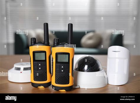 Cctv Camera Walkie Talkies Smoke And Movement Detectors On Wooden Table Indoors Home Security