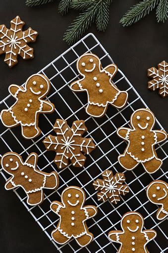 가문비 나무 바늘 검은 배경 높은 보기에 둘러싸인 흰색 금속 냉각 랙에 흰색 왕실 장식 으로 장식 된 수제 진저 브레드 남자와 눈송이 비스킷의 이미지 배치 0명에 대한 스톡